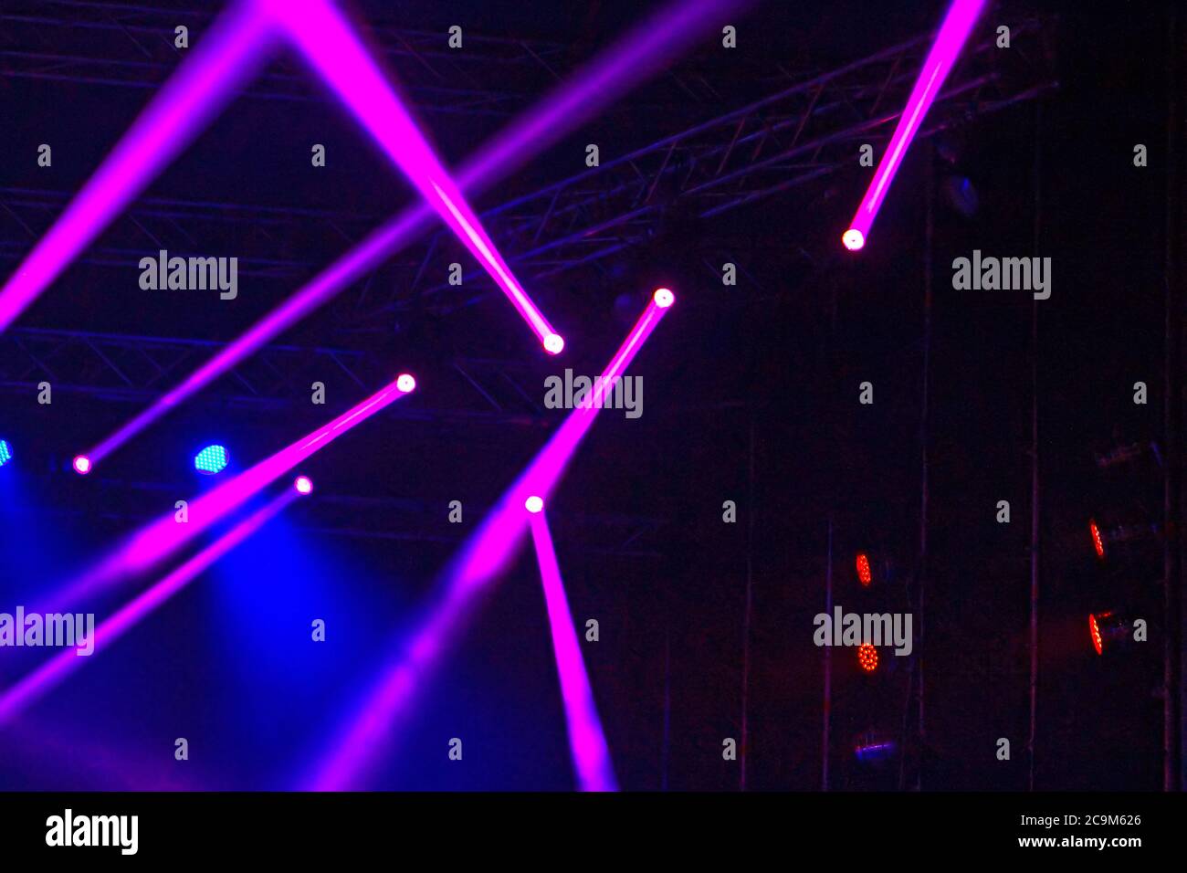 Purple and blue rays of light on stage in the dark Stock Photo - Alamy