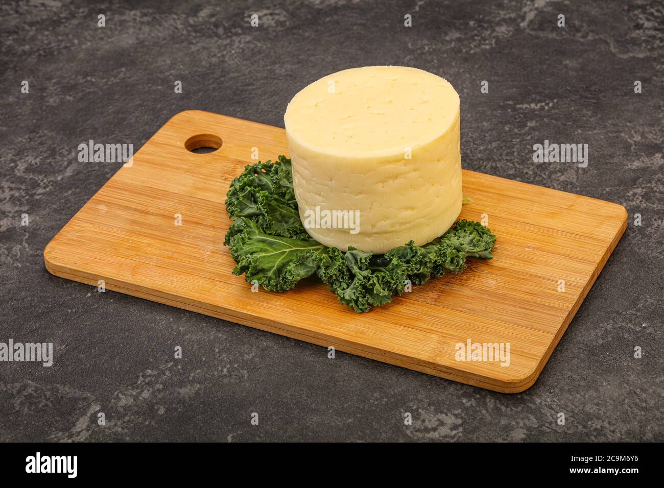 Yellow round dairy soft cheese piece Stock Photo - Alamy