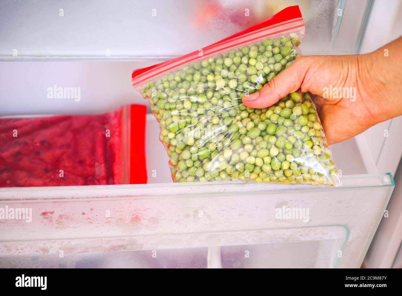 Woman putting food in fridge hi-res stock photography and images - Alamy