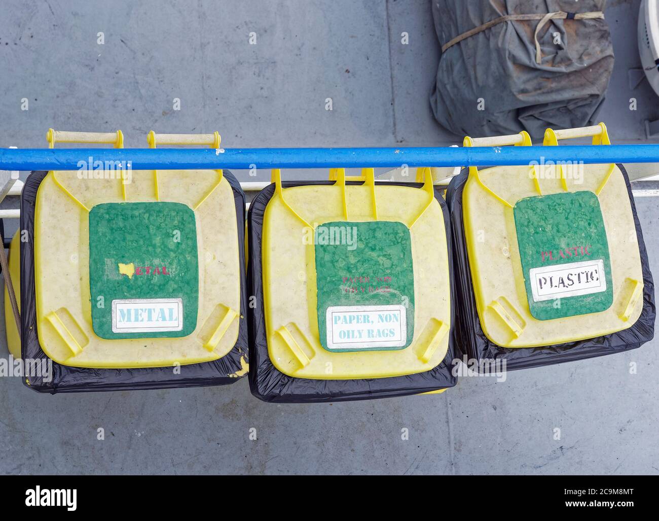 Three yellow wheelie bins for the segregation of garbage on the deck of ...