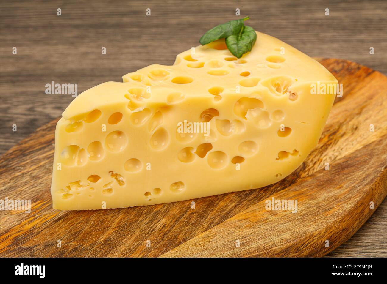 Maasdam cheese - dairy yellow triangle with holes Stock Photo - Alamy