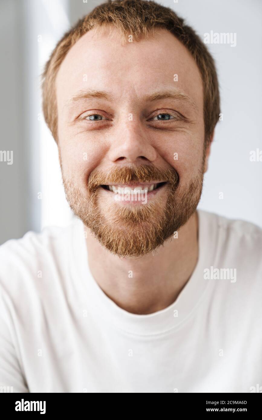 Photo of joyful handsome man with red hair posing and smiling on camera indoors Stock Photo - Alamy