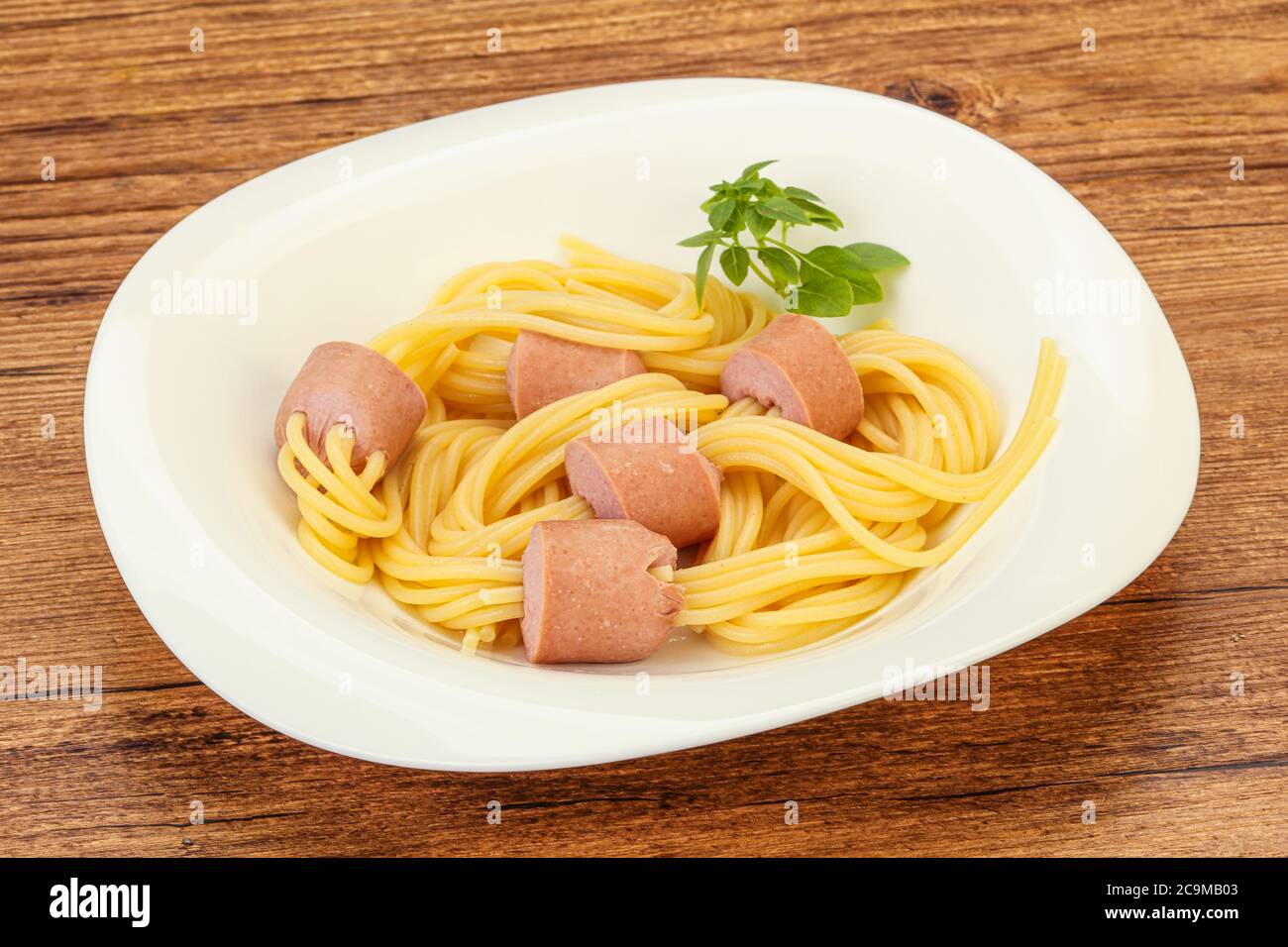 Kids pasta spaghetti with sausages and basil Stock Photo - Alamy