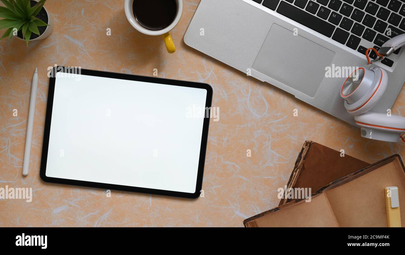 The top view of the table is surrounding by a computer tablet and ...
