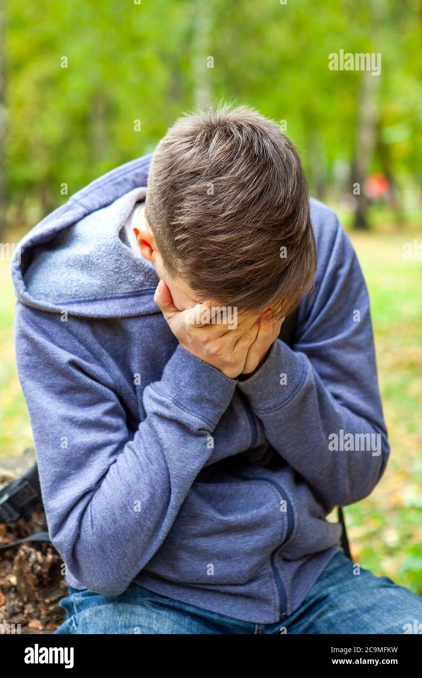Sad Young Man in the Park hide his Face and Crying Stock Photo - Alamy