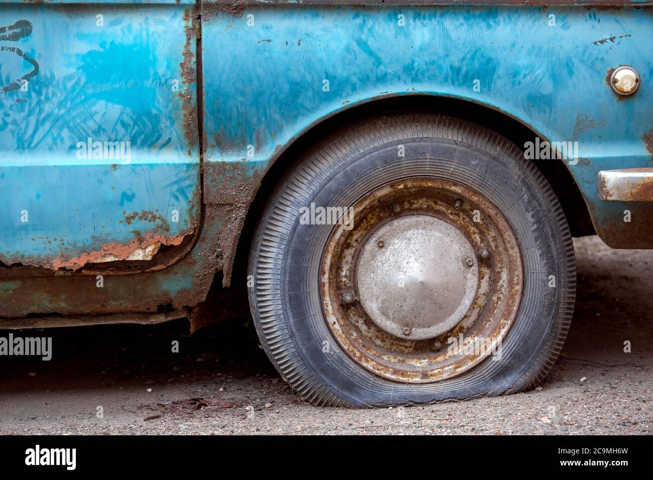 Tire leak, close up of wheel of old rusty car blue color Stock Photo ...