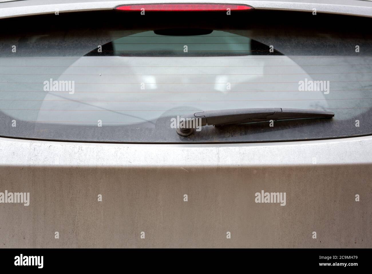 rear window wagon with a car wiper in a layer of dirt, close up of the ...