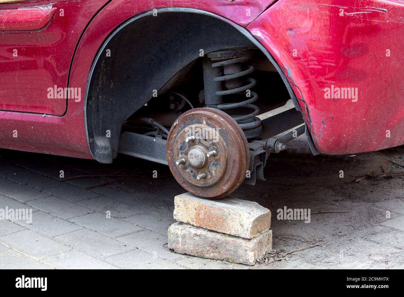 Car without wheels costs on brick, old rusty car brakes in poor ...