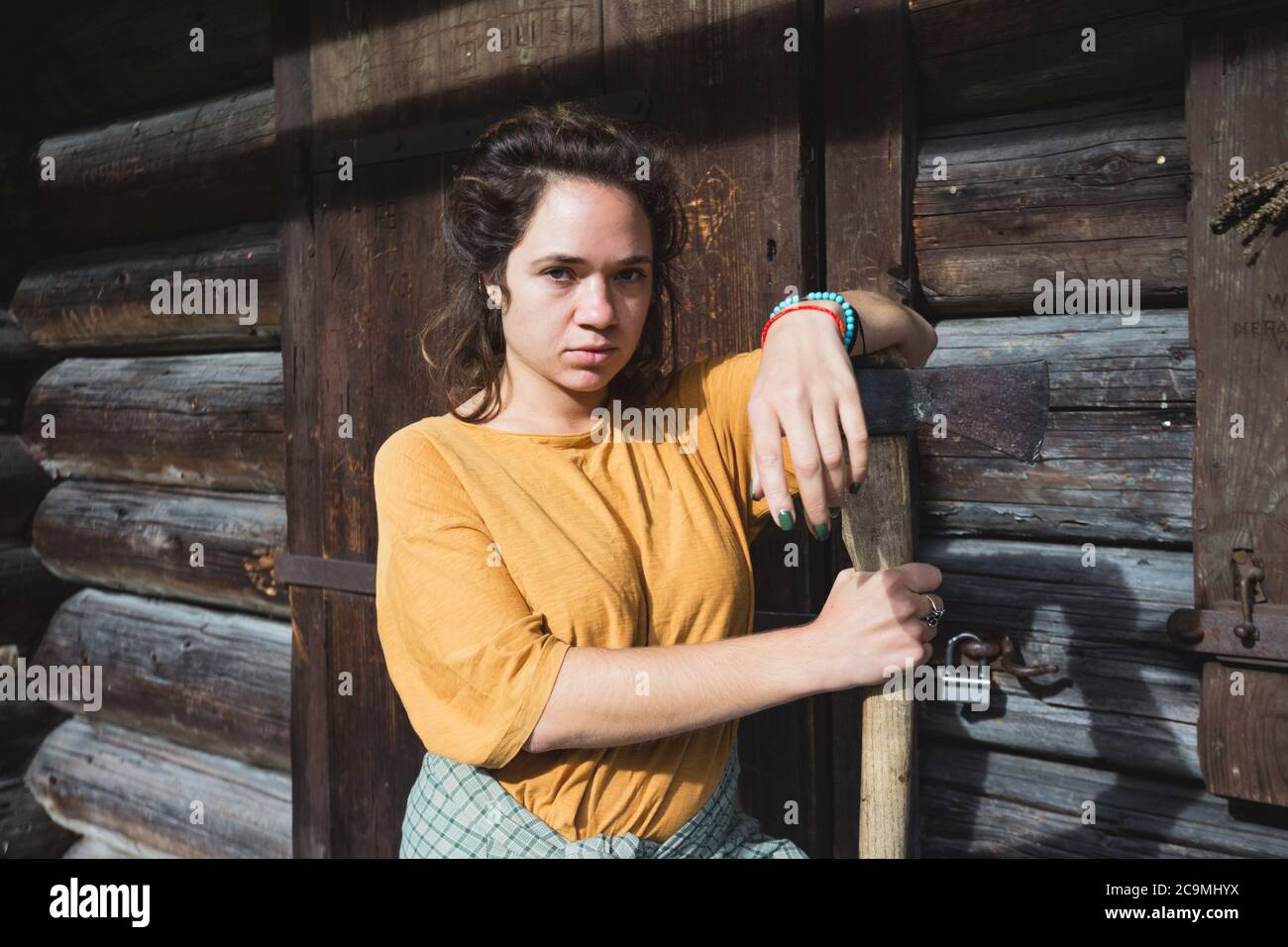 girl with an ax near a wooden house in the mountains Stock Photo - Alamy