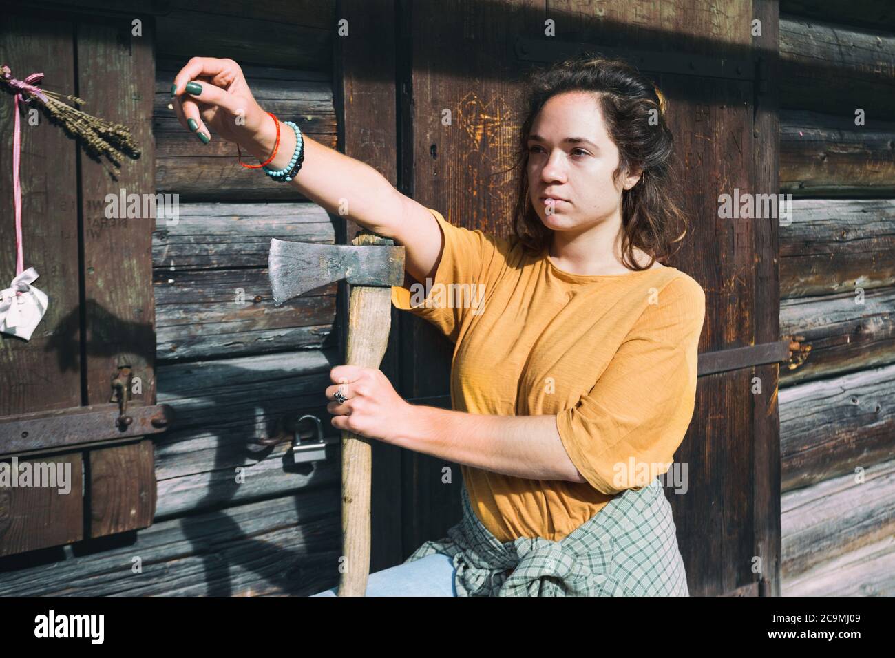 girl with an ax near a wooden house in the mountains Stock Photo - Alamy