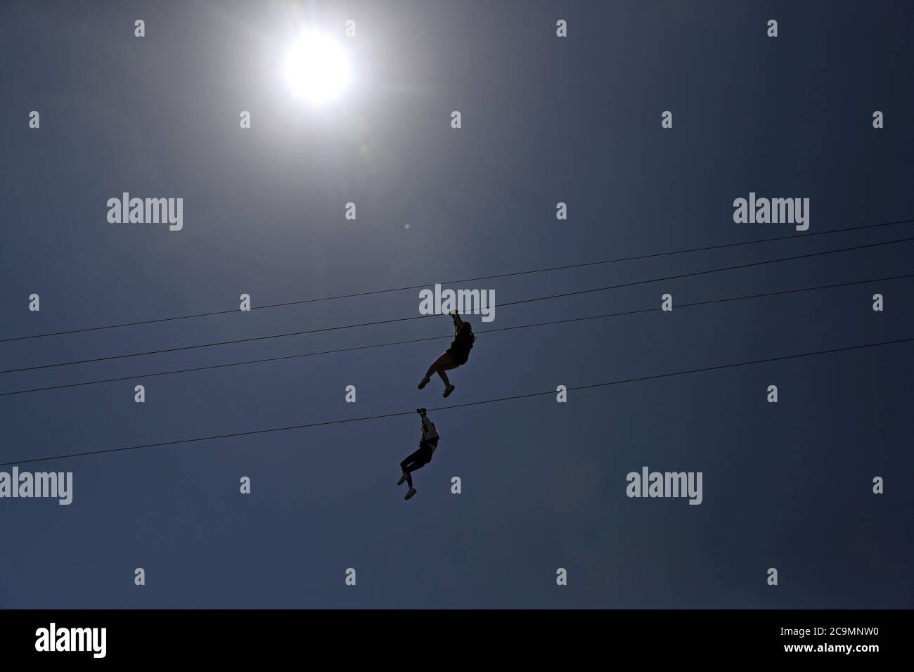 A person uses a zip line as people the hot weather on Brighton beach in ...