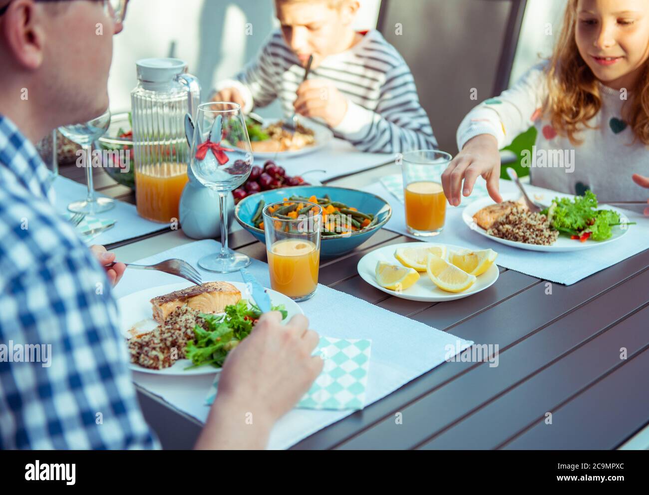 Happy family eating healthy dinner together on terrace at home Stock ...
