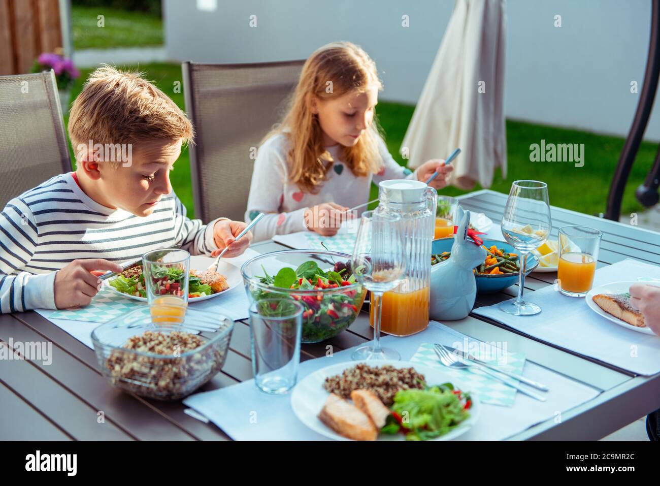 Happy family with two teen children eating healthy dinner together on ...