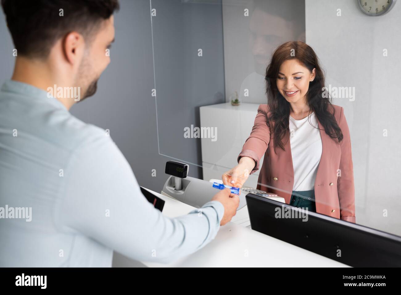 Shop Cashier In Store Or Hotel Reception Taking Credit Card Stock Photo ...