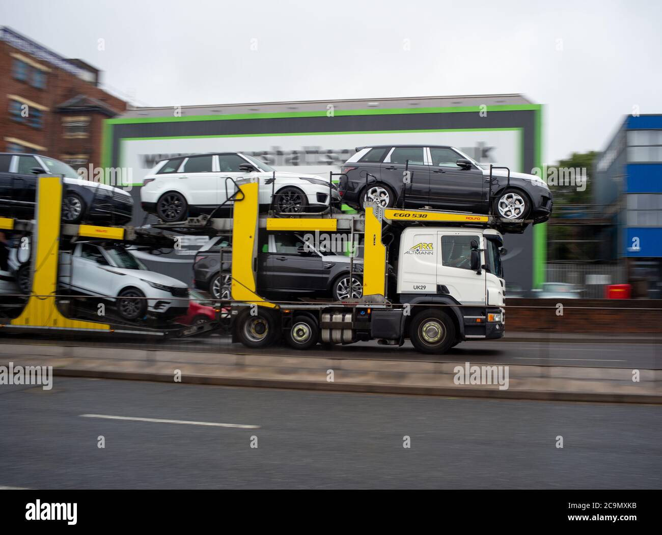 Car transporter moving along the road loaded with range rovers on its ...