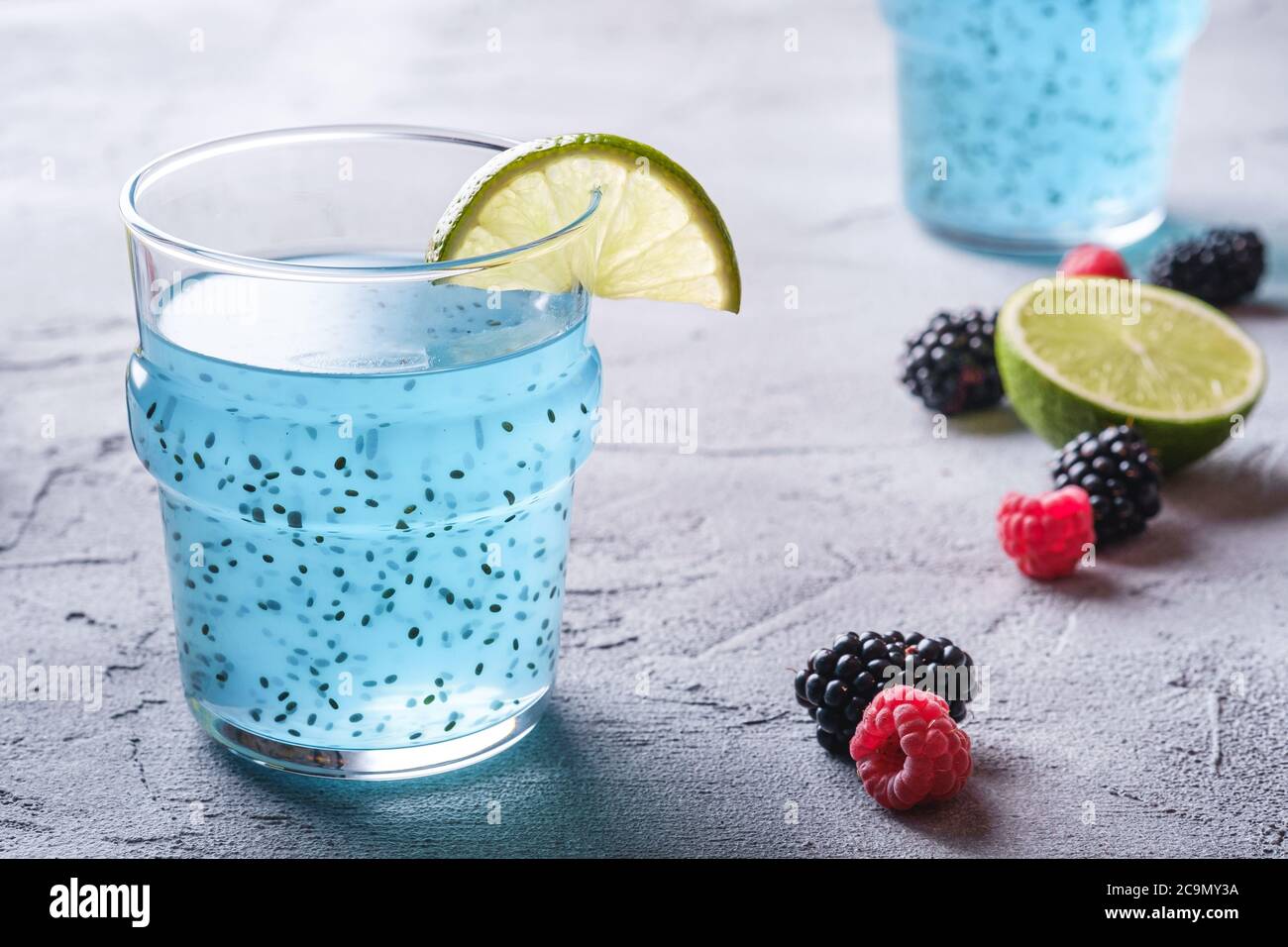 Tasty blue colored cocktail drink with basil chia seeds, citrus lime ...