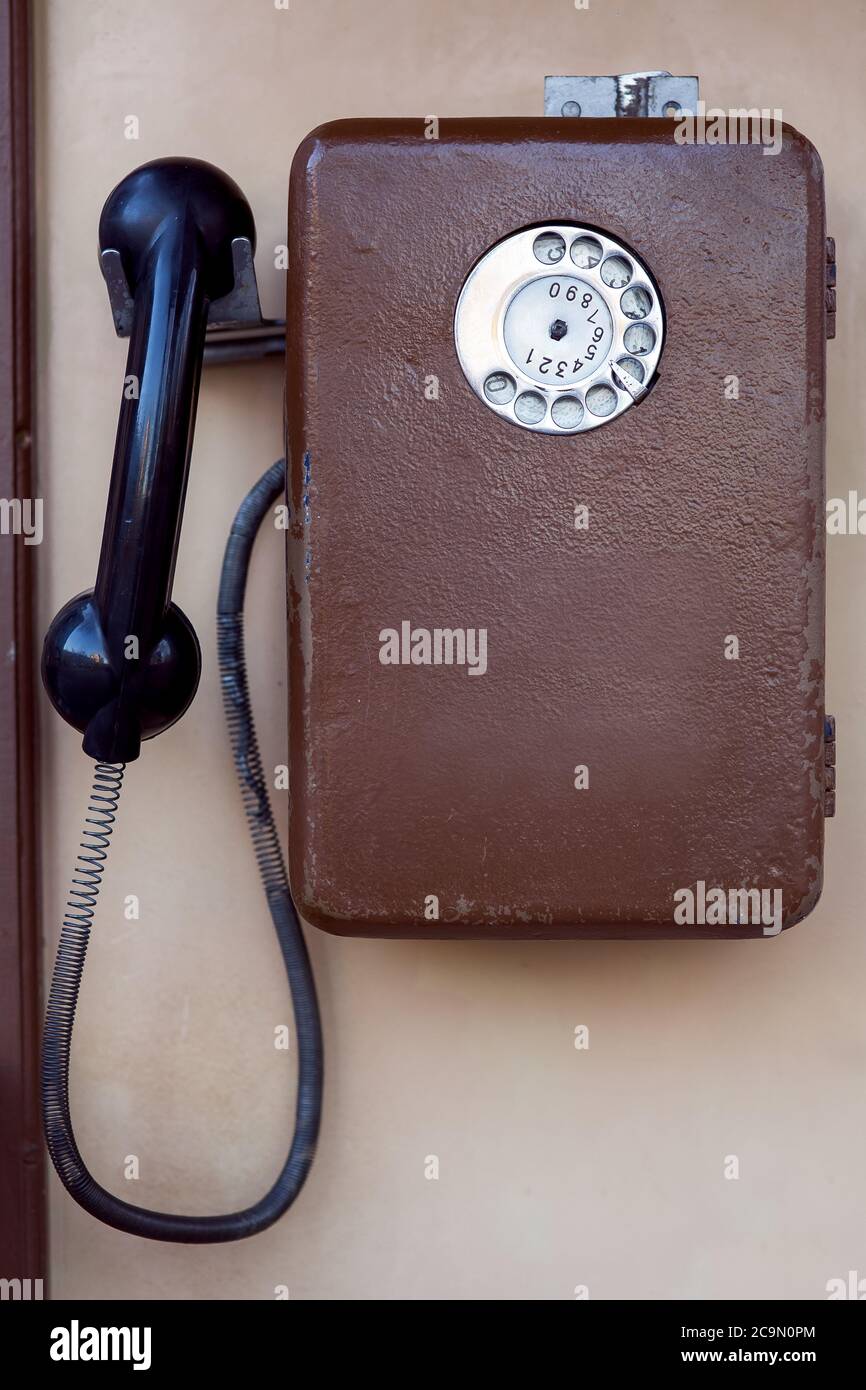 The payphone, old street phone with a black tube and the brown metal ...