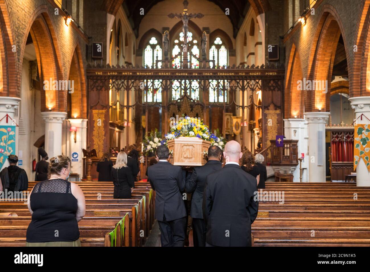 Coffin being carried into a church at a socially distanced funeral ...