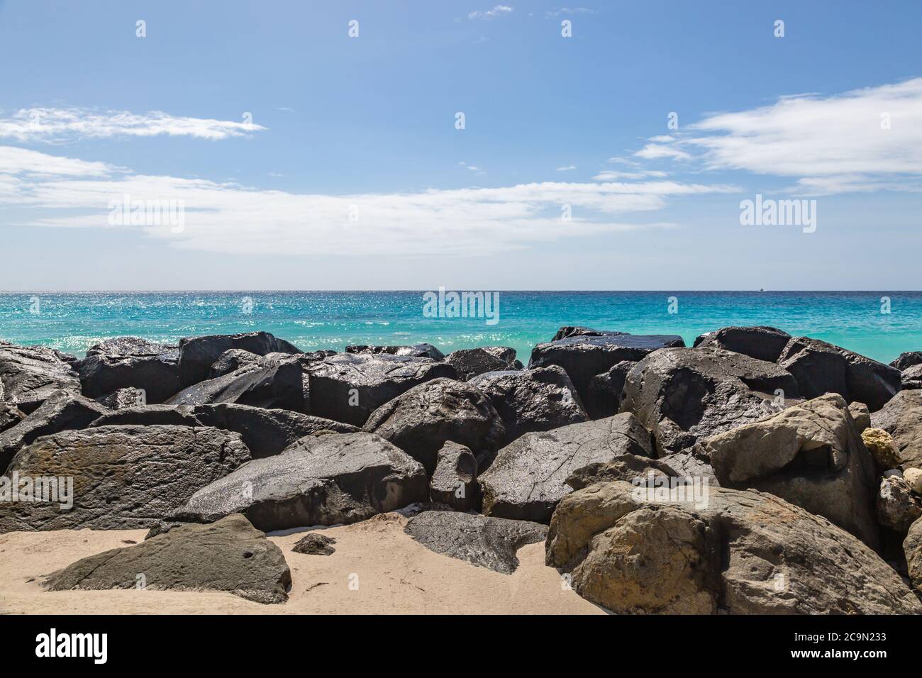 Rocks at the water's edge, on a beach in Barbados Stock Photo - Alamy