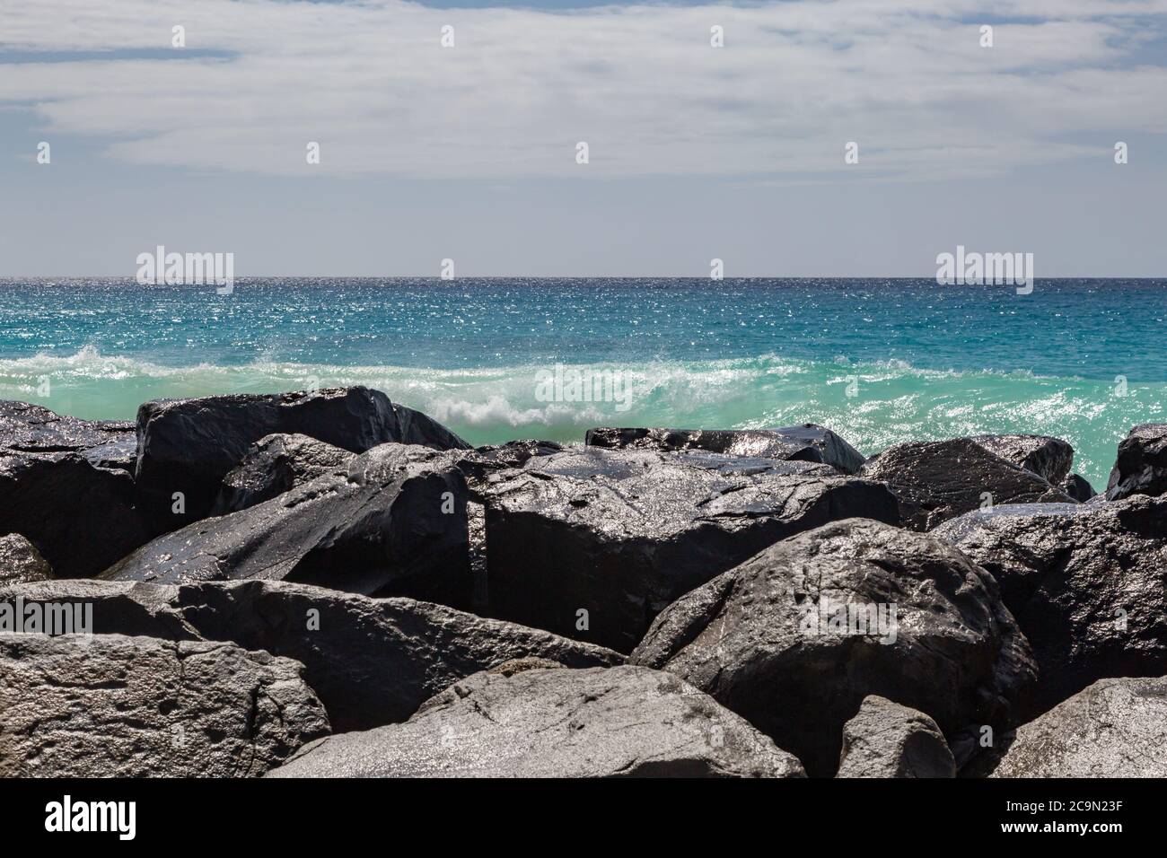 Rocks at the water's edge, on a beach in Barbados Stock Photo - Alamy