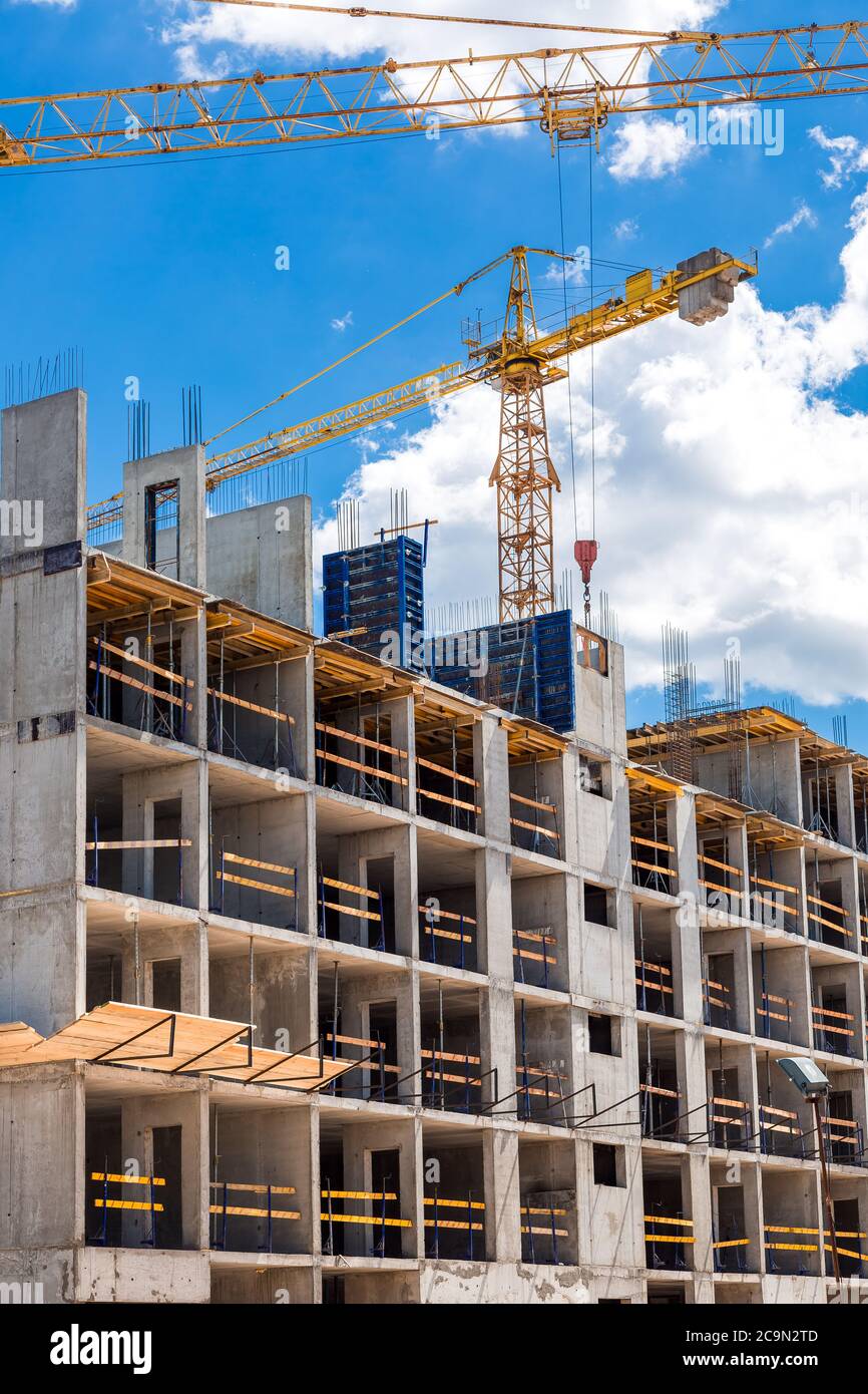 High rise building under construction, seen from below against blue sky ...