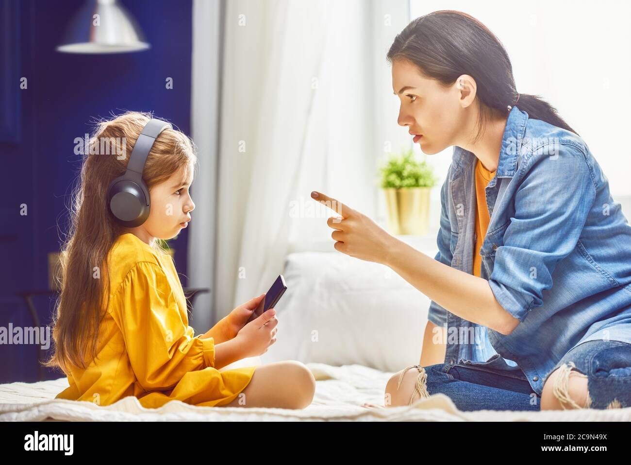 Mother is scolding her child girl playing on phone. Family relationships Stock Photo - Alamy
