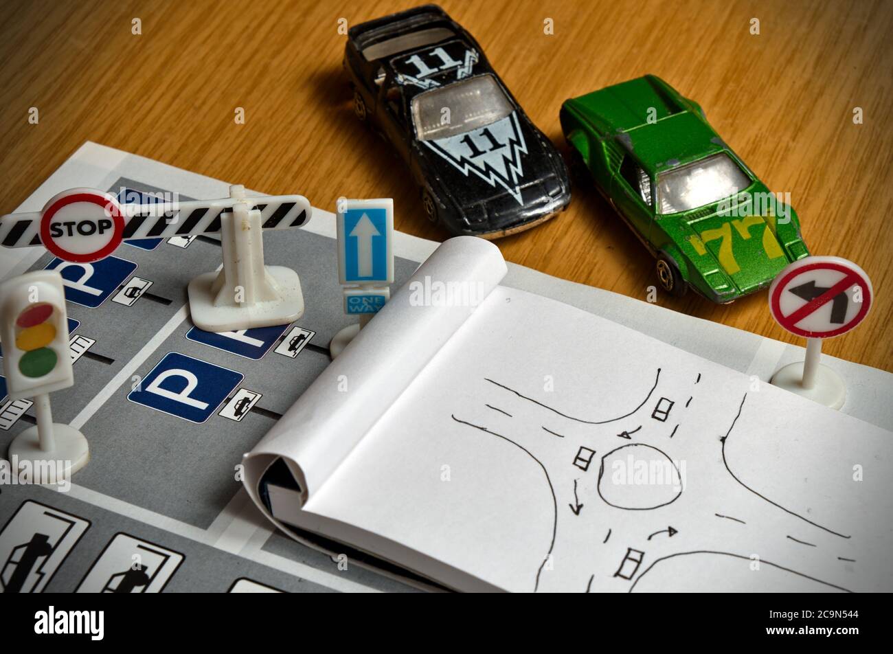 Notepad, book of traffic rules, toy cars, traffic lights and stop sign ...