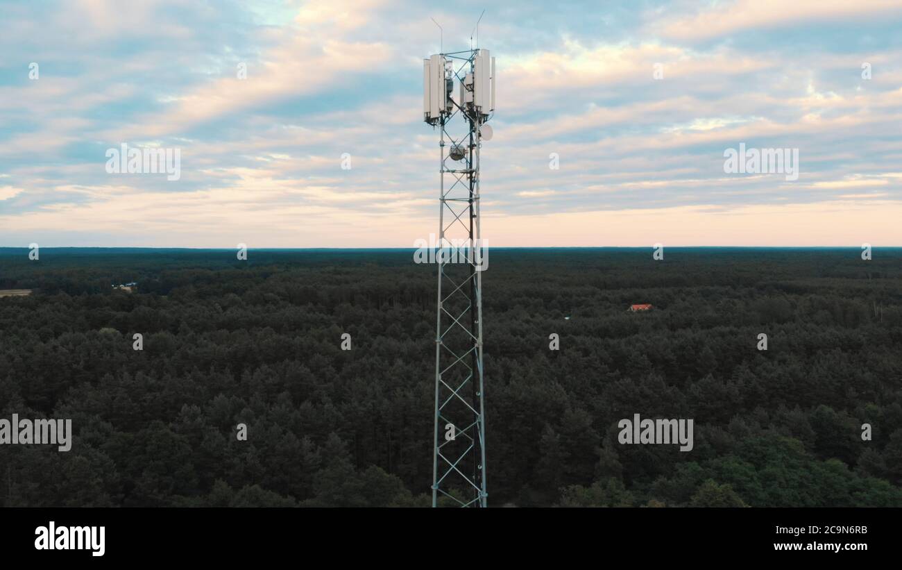 5G, Communication tower rising above the apple fields. Aerial with copy ...