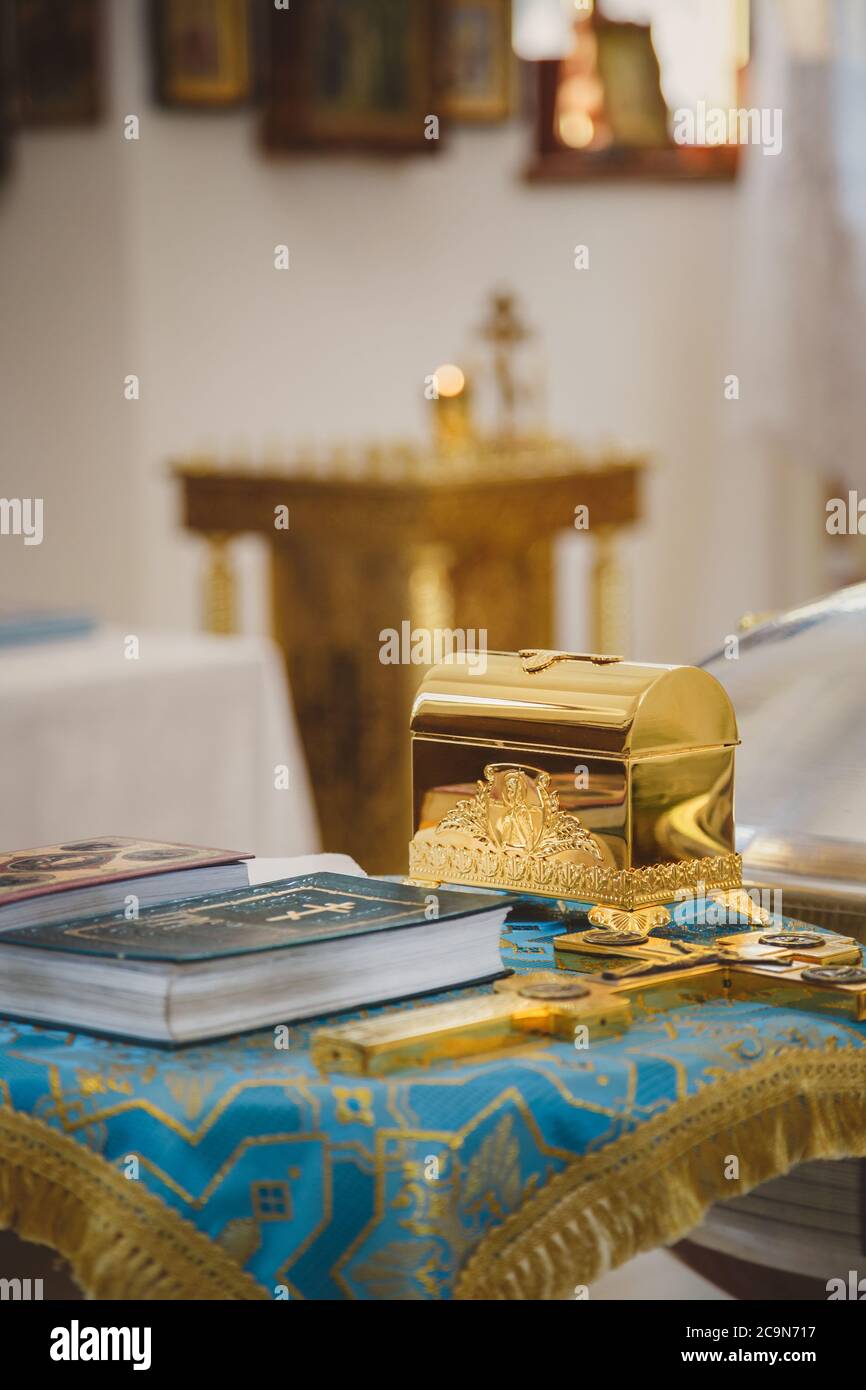 Christening in the church, golden religious utensils: bible, cross ...