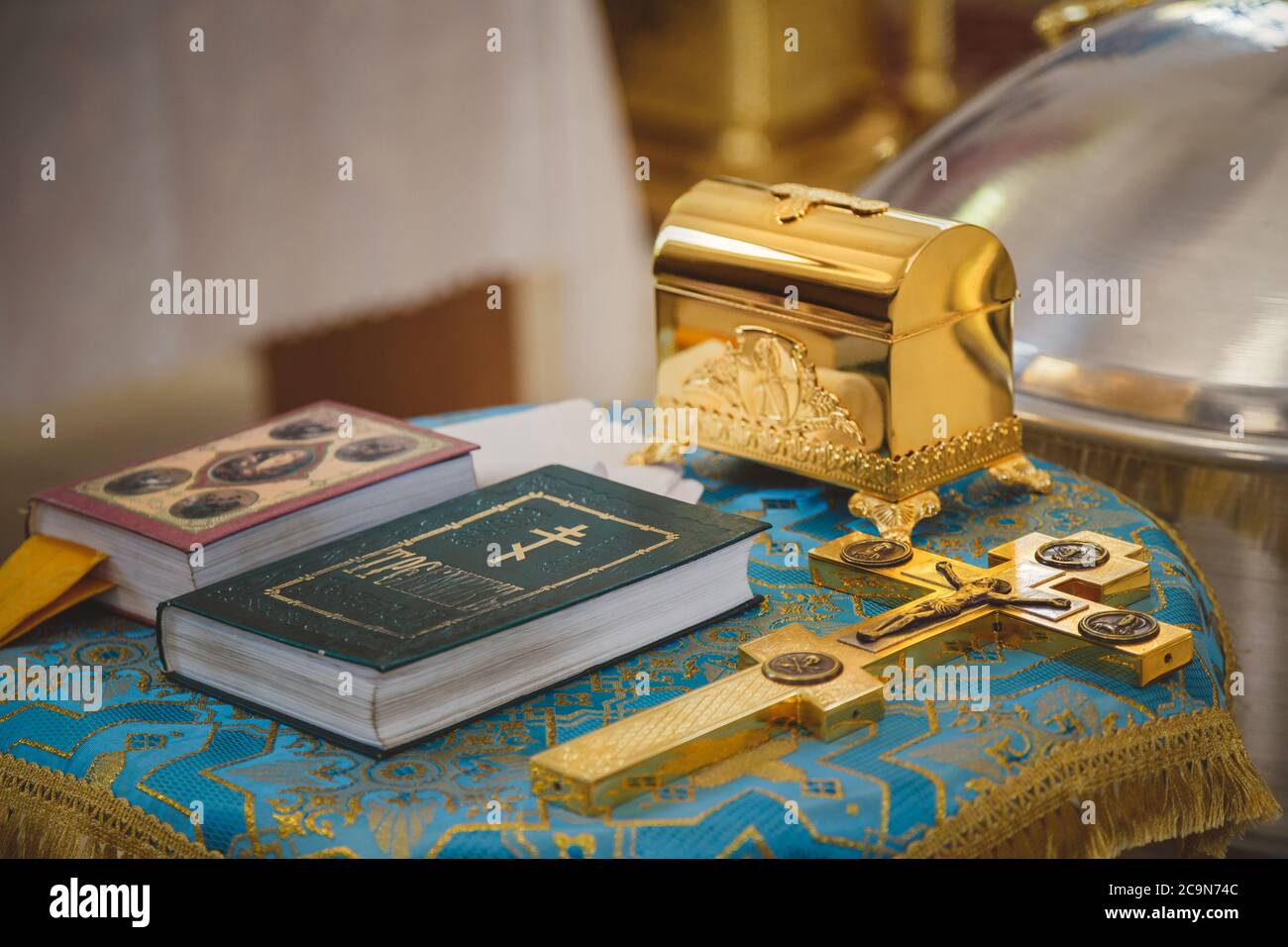 Christening in the church, golden religious utensils: bible, cross ...