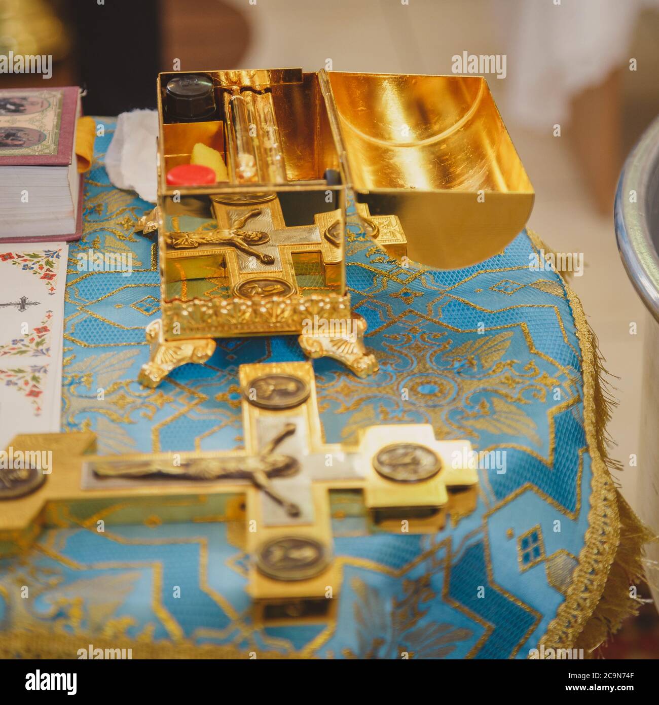 Christening in the church, golden religious utensils: bible, cross ...