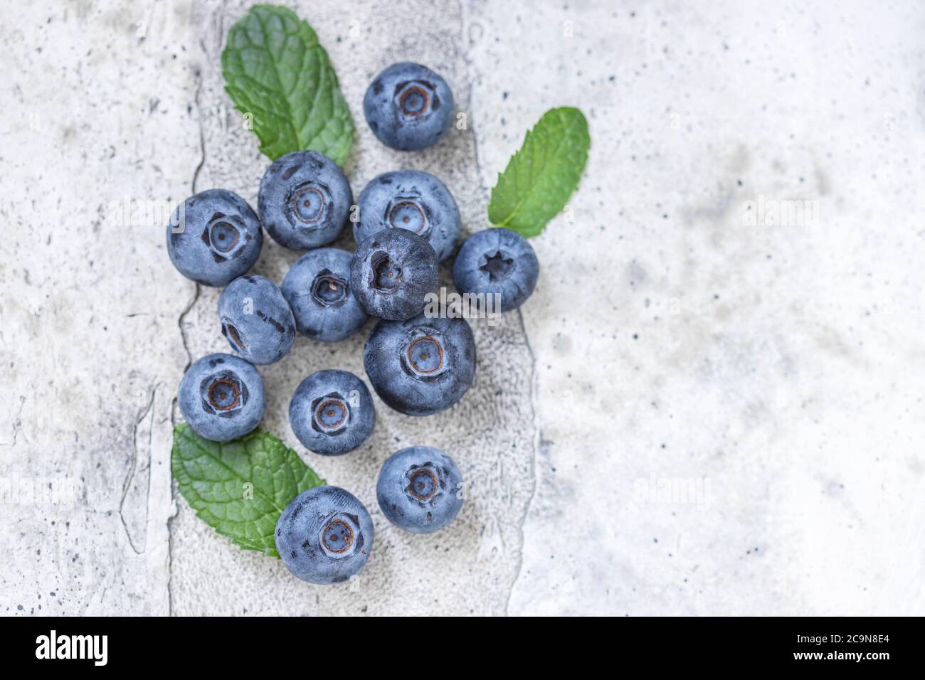 Fresh blueberries in on light gray concrete background with copy space ...