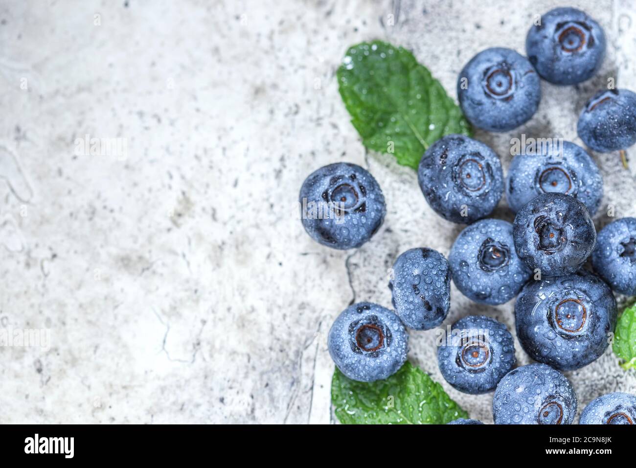 Fresh blueberries in on light gray concrete background with copy space ...