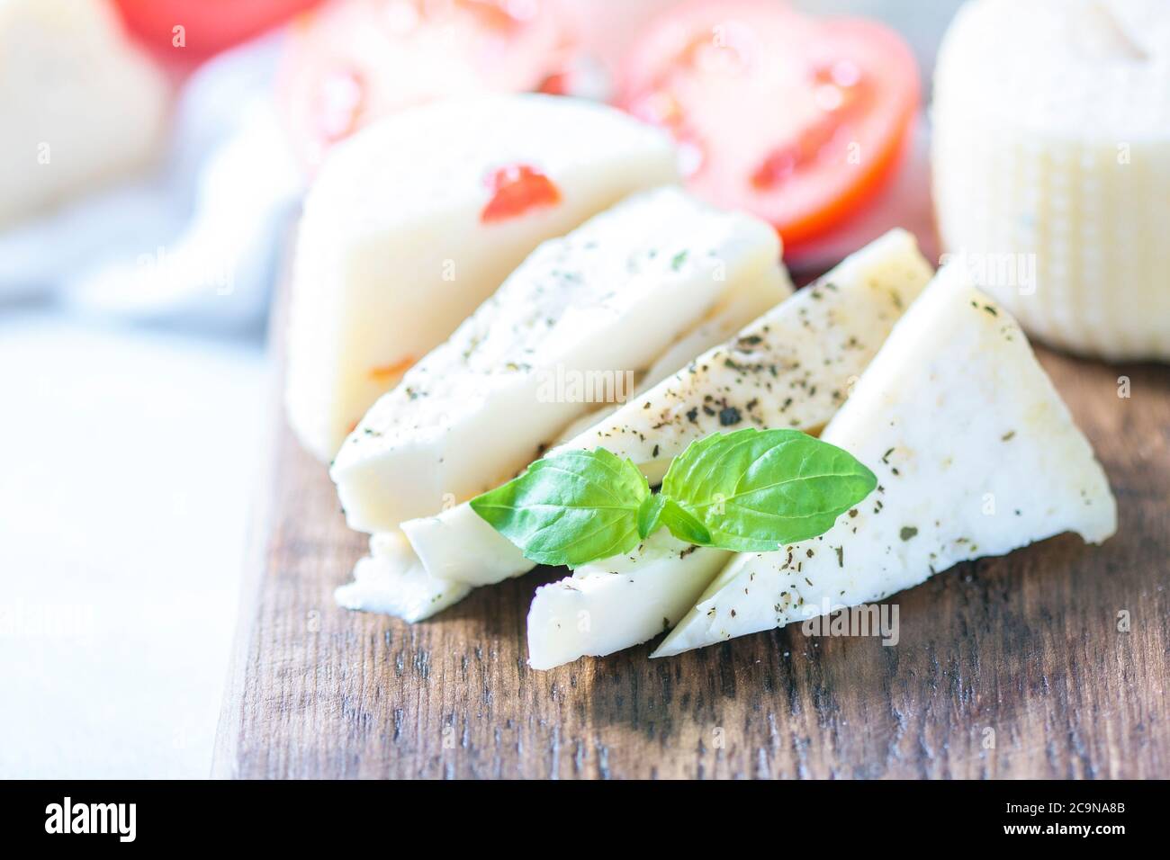 Homemade cheese halloumi with herbs on a light background. Copy space ...