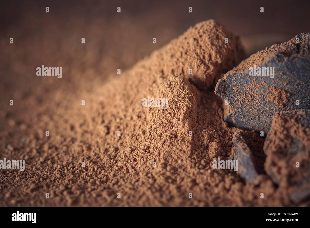 dark chocolate, cocoa solids and cocoa powder over wooden background ...