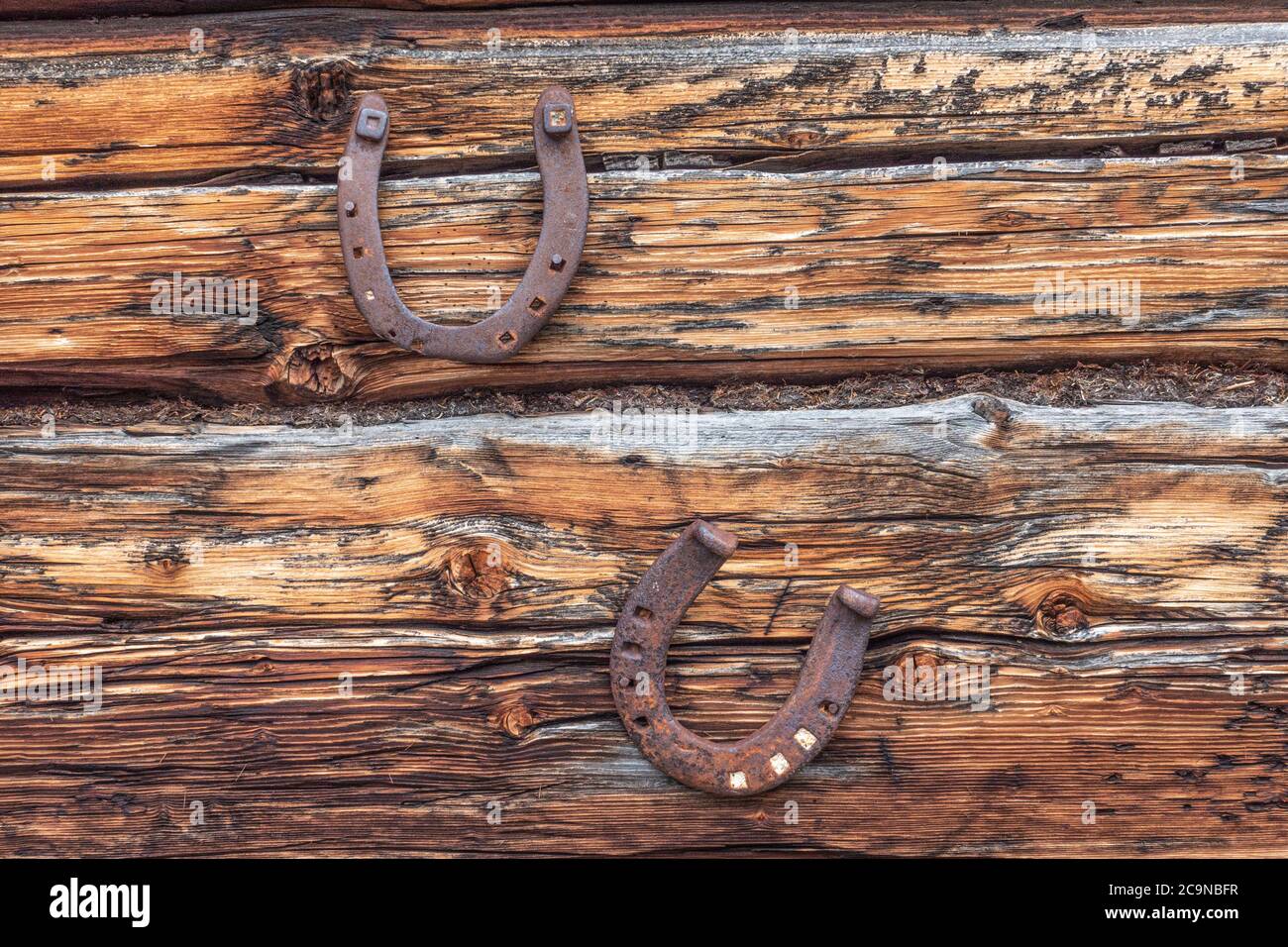 Two horseshoe irons on rustic mountain shack wall Stock Photo - Alamy