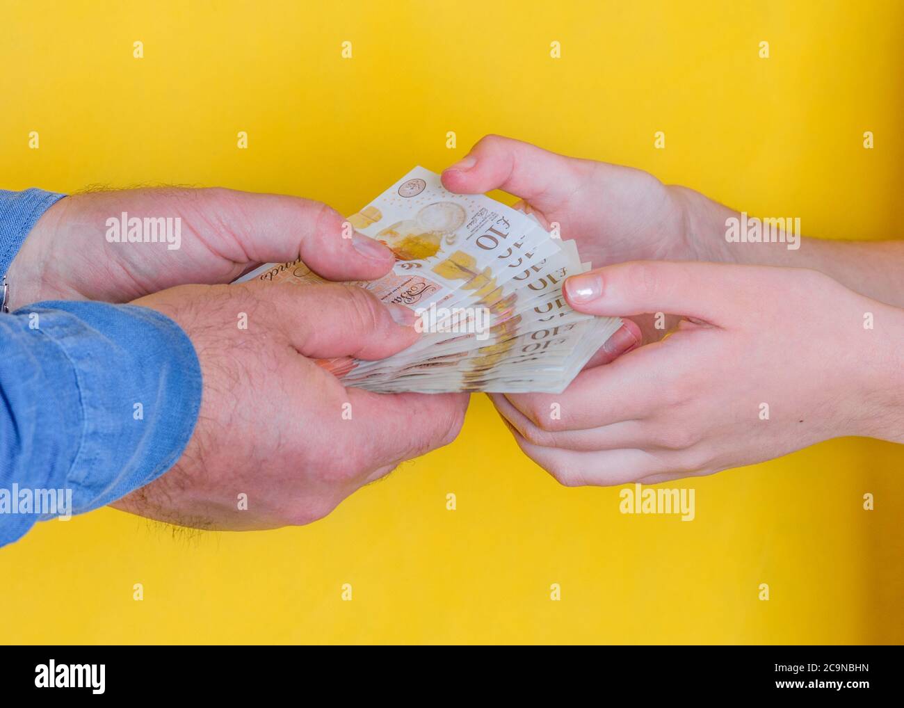 people passing money each other on yellow background Stock Photo - Alamy