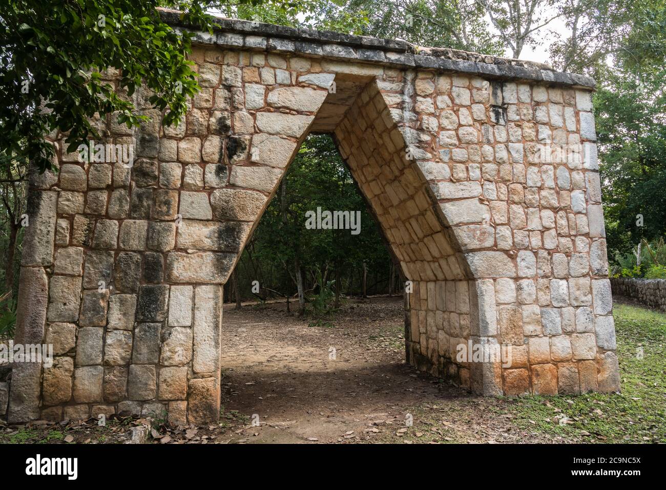 An arched stone gateway in the ruins of the great Mayan city of Chichen ...