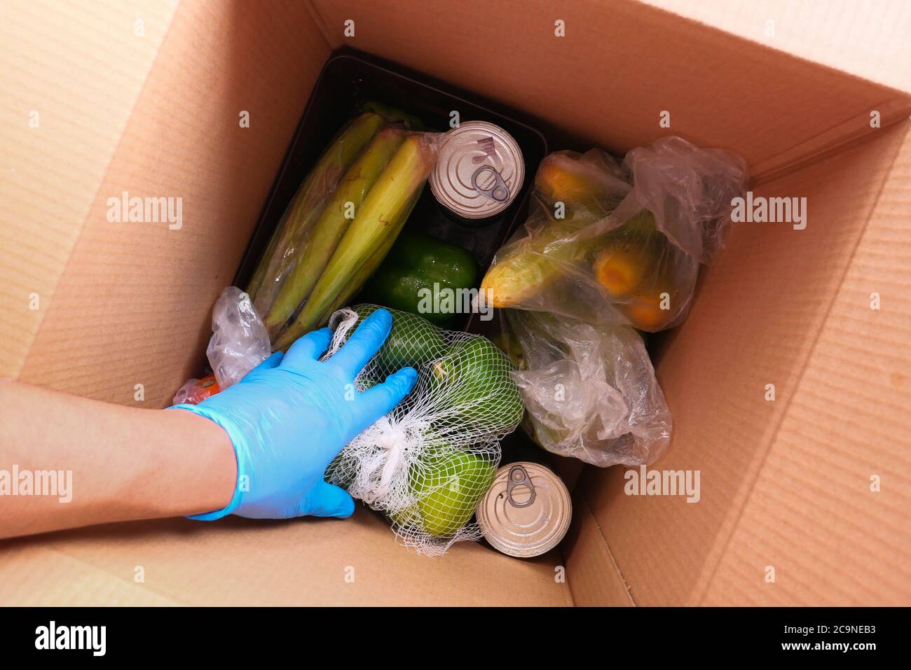 Door delivery of goods. Order picker packing foods in a cardboard boxes ...
