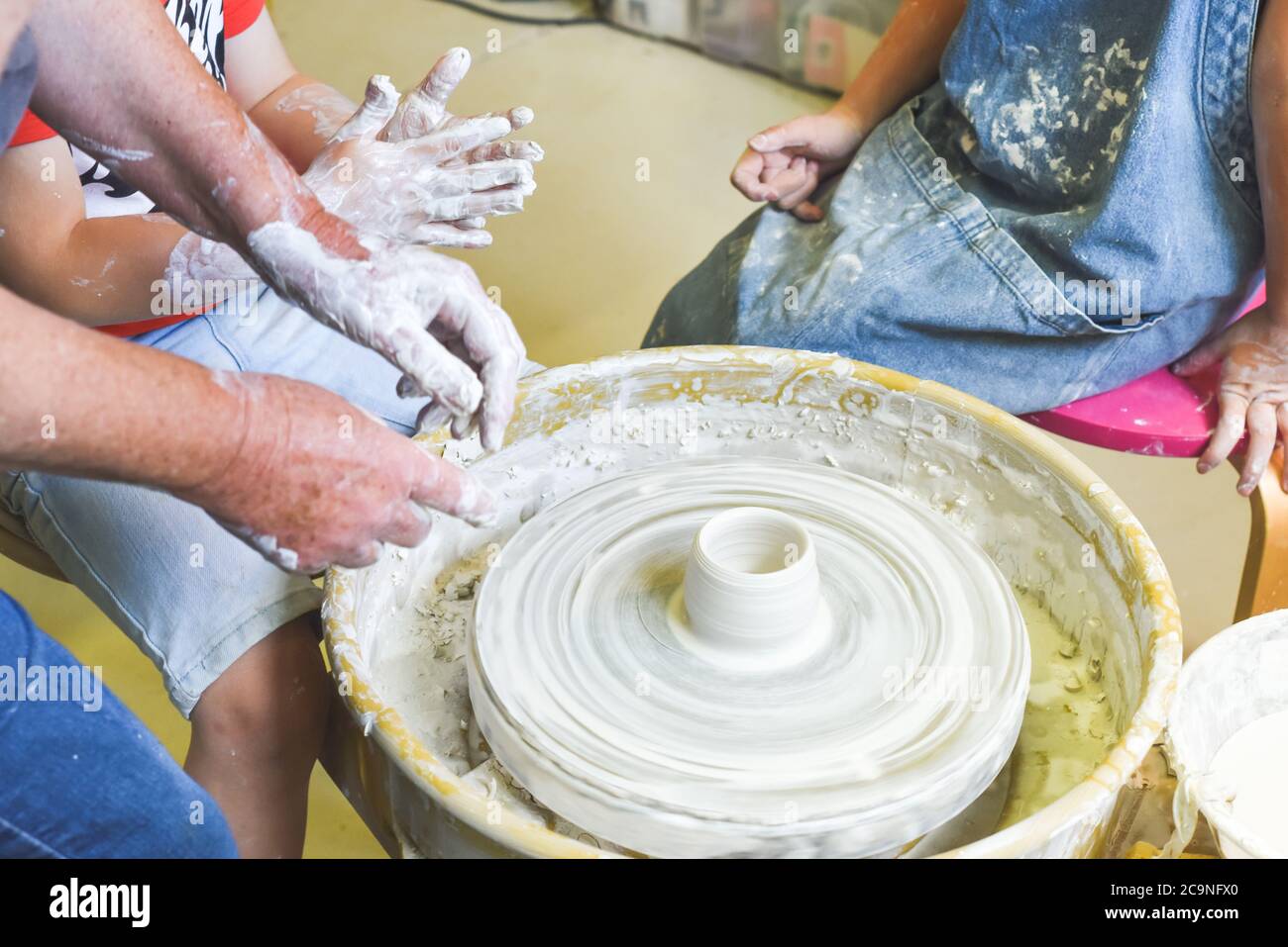 Children learning to make pottery as a hobby with their grandmother in ...