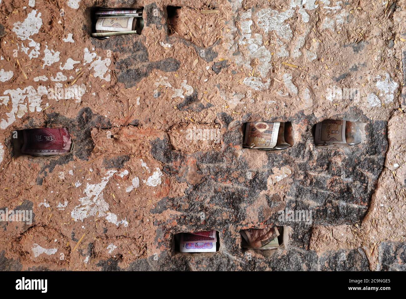 Money offerings inside holes-adobe wall-chapel in Thirtythree Heaven ...