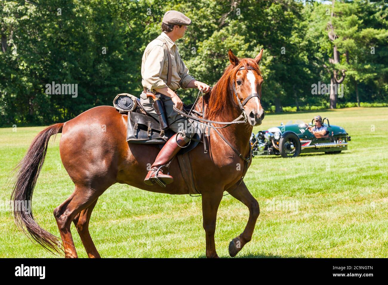 Man riding a horse in the foreground and a man driving a Morgan 3 ...