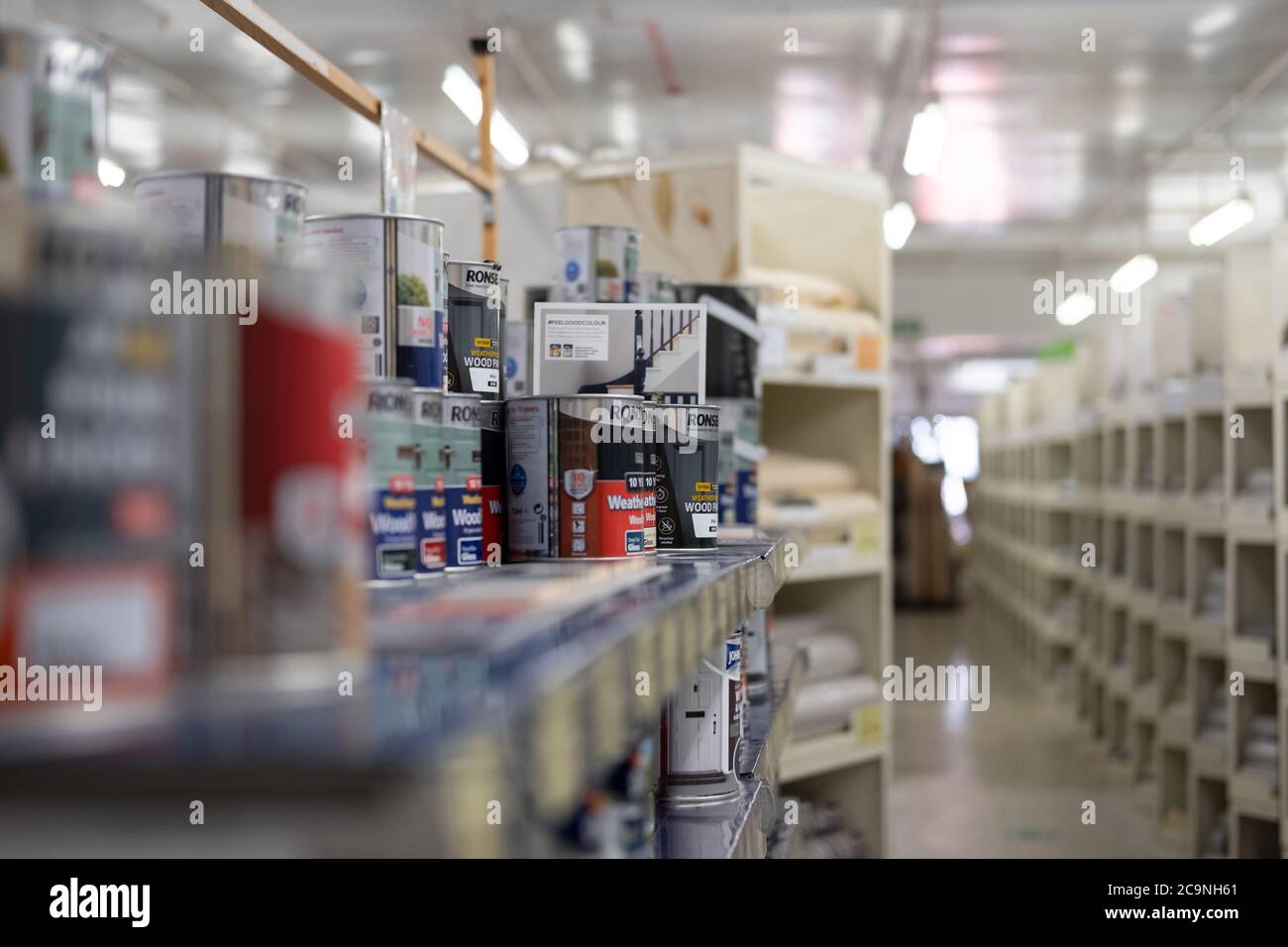 Shallow focus of large tins of DIY paint seen within a well-known DIY ...