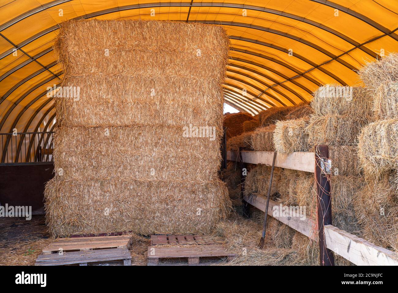 Hay bale storage in a farm building Stock Photo - Alamy