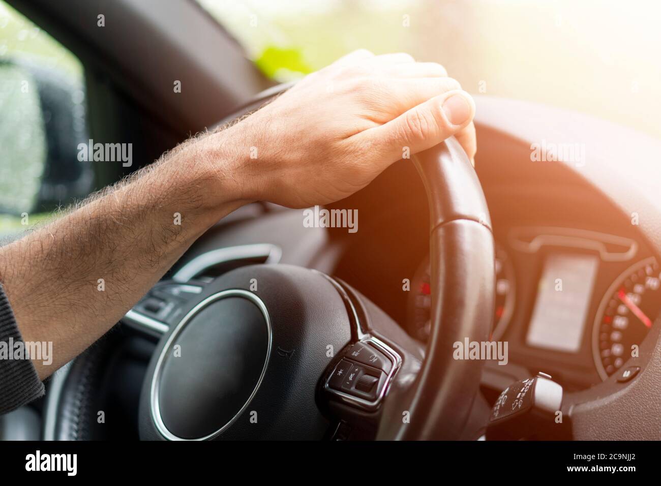 Male hands holding car steering wheel. Hands on steering wheel of a car driving. Young Man ...