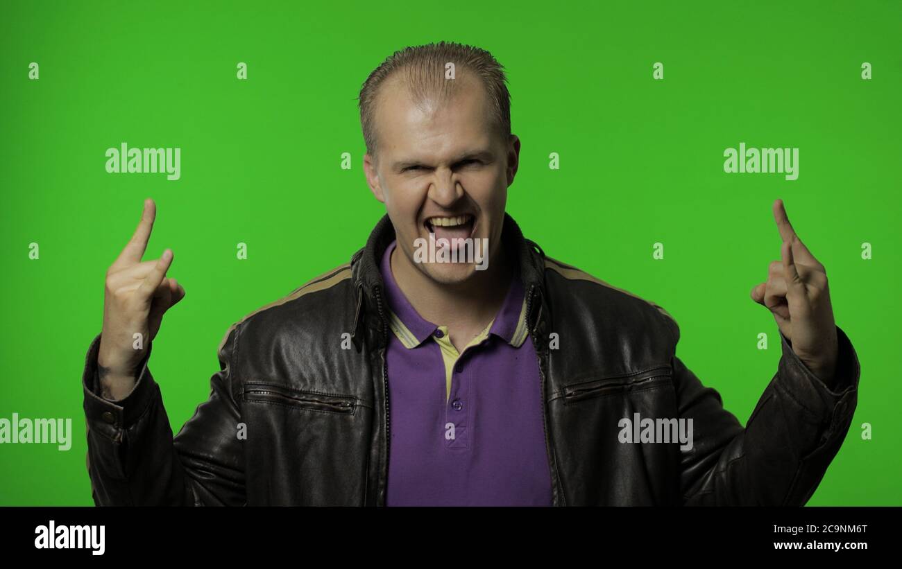 Happy rocker man in brown leather jacket showing rock and roll sign ...
