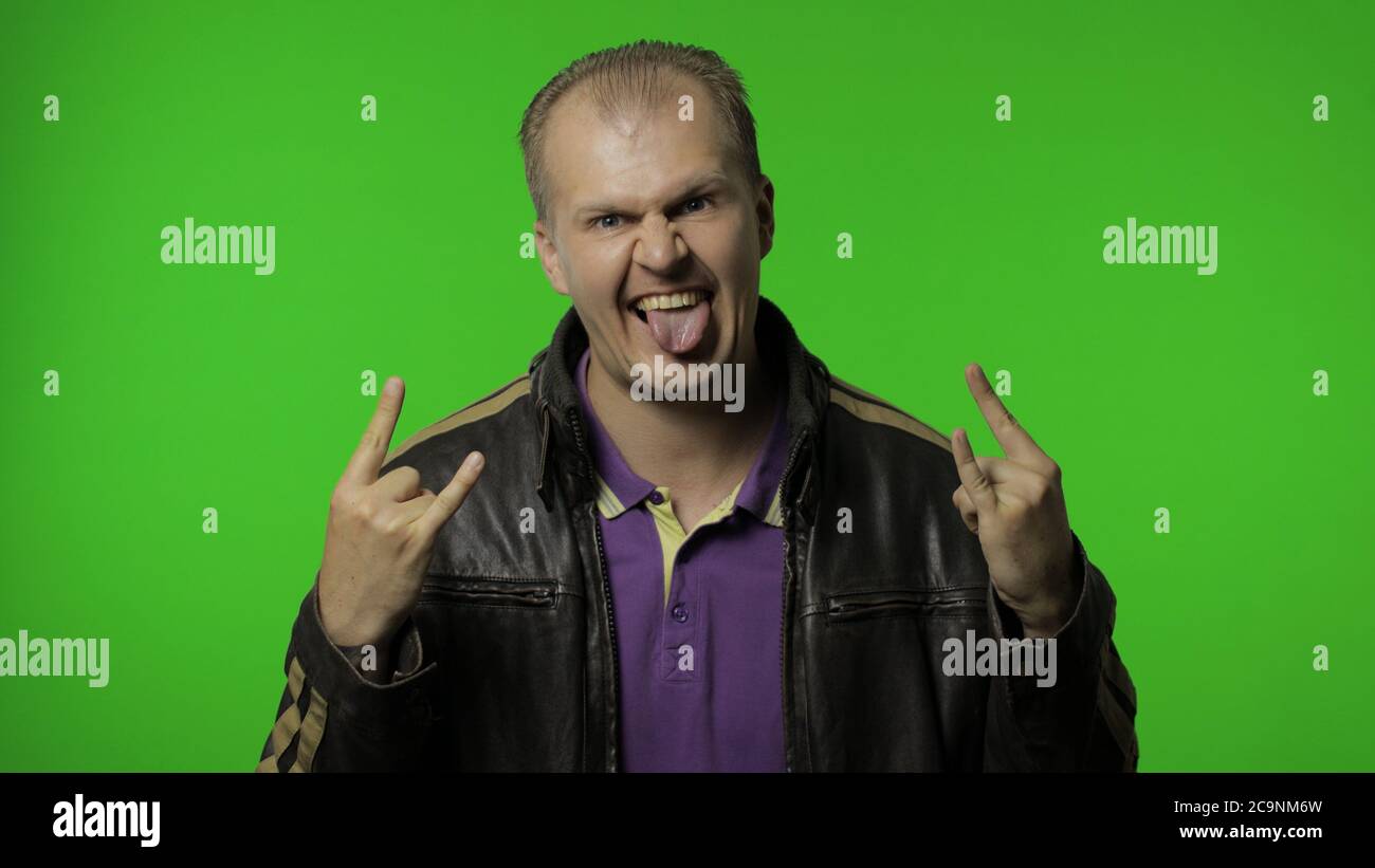 Happy rocker man in brown leather jacket showing rock and roll sign ...