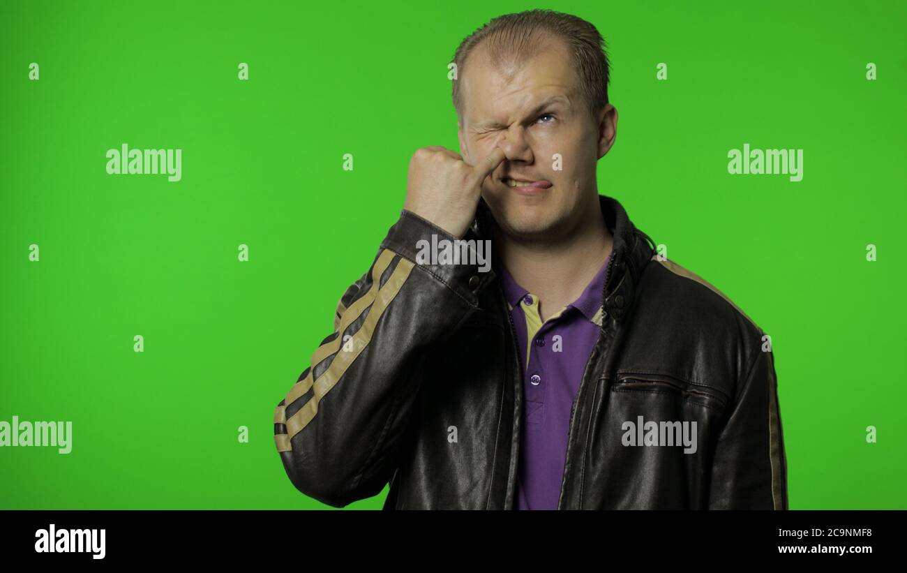 Funny stupid rocker man in jacket picking nose with silly brainless ...
