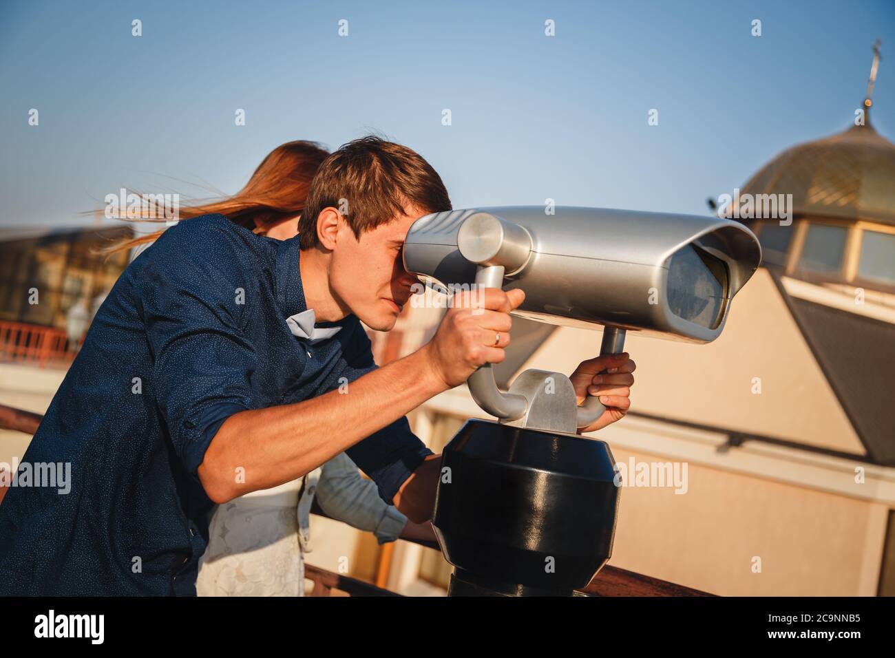 Happy romantic attractive young couple looking at binoculars from the ...