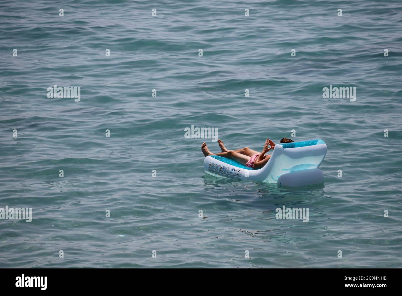 Paguera, Spain. 01st Aug, 2020. On the island of Mallorca, a man is floating on the beach on an ...